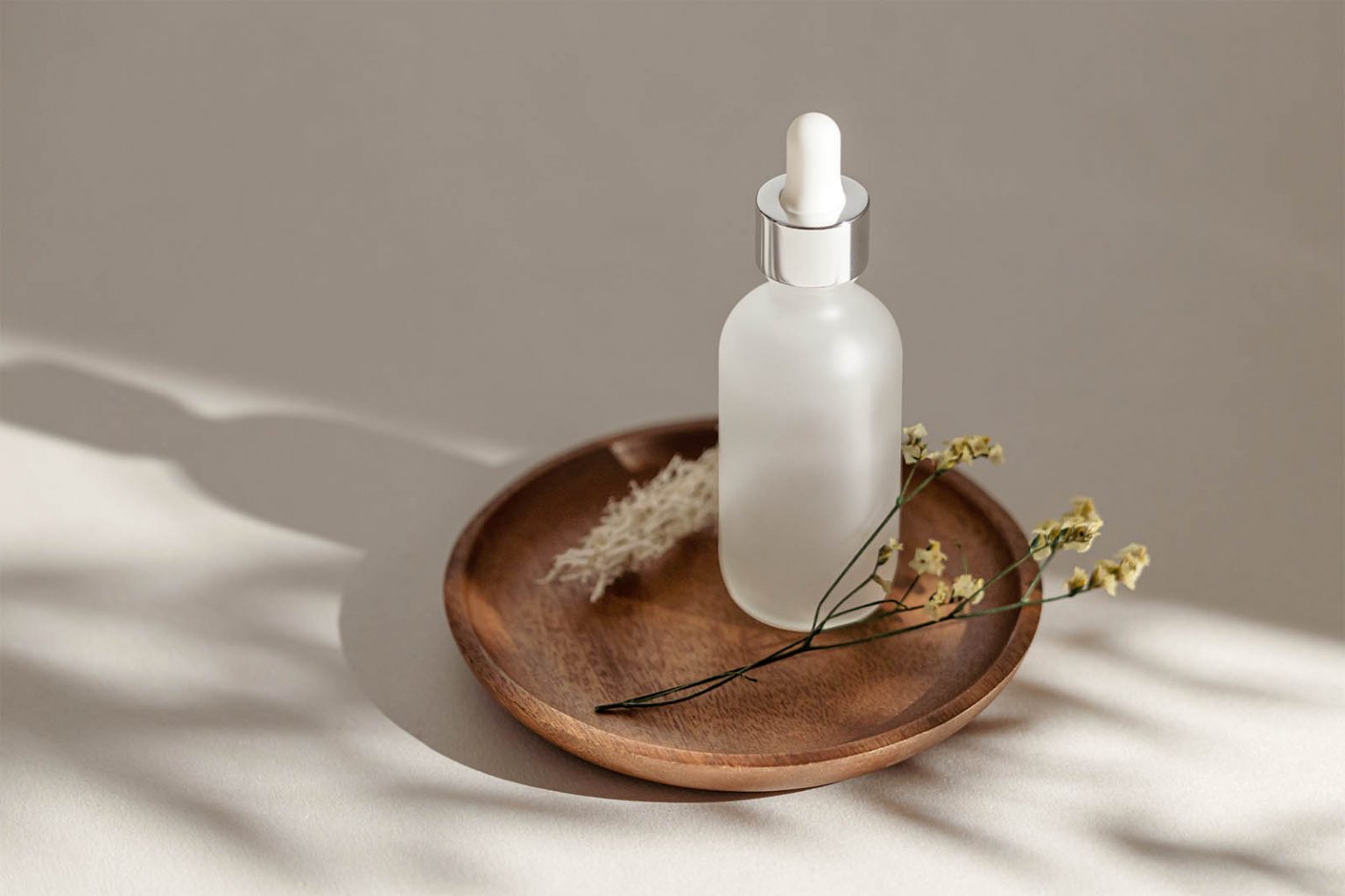 Frosted dropper bottle on wooden tray mockup - Mockups Design